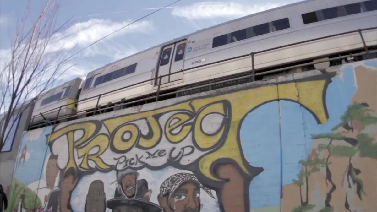 subway train on elevated track in Jamaica Queens graffiti wall spray p ...